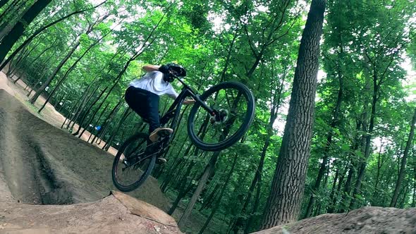 Forest Ramps and a Bike Rider Doing Dirt Jumping Over Them, Stock Footage