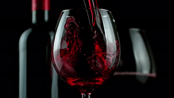 Super Slow Motion Shot of Pouring Red Wine on Black Background at ...