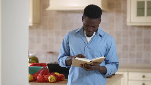 Focused Young African American Man Reading Recipe Looking Back at ...