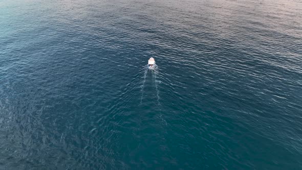 Fishing boat far out to sea at sunset, Stock Footage | VideoHive