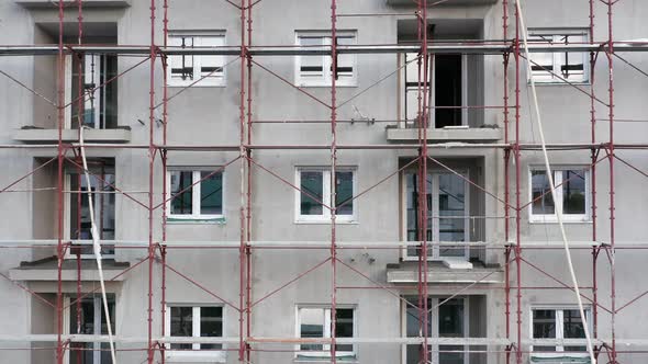 Scaffolding in front of the exterior of a high-rise building plastered ...