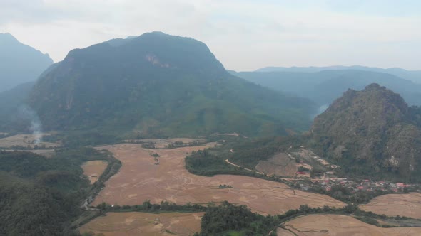 Aerial: flying over rice paddies unique valley scenic cliffs rock ...