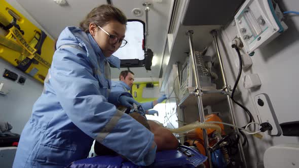 Paramedic Putting Oxygen Mask on Patient in Ambulance, Stock Footage