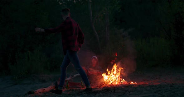 Mans Jumping Over Bonfire on the Beach at Night Young Woman Tourist is ...