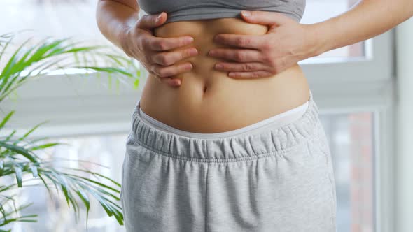 Woman Compressing the Skin on Her Stomach and Sides Checking for Excess ...