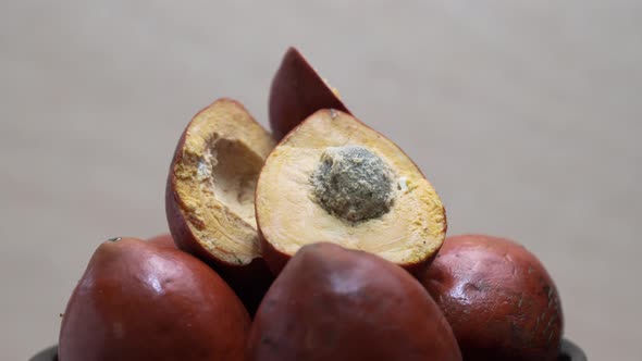 Close up shot of rotating fresh ripe Chontaduro Fruit in front of white ...
