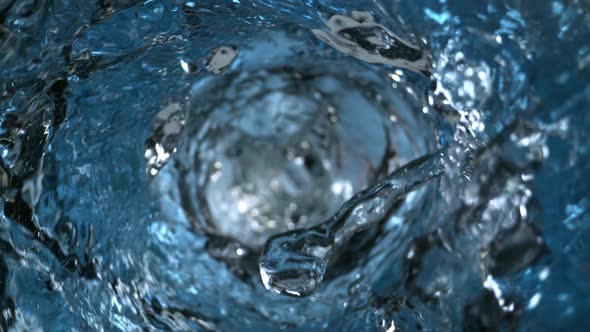 Super Slow Motion Shot of Water Whirling and Splashing in Glass Bottle ...