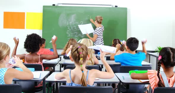 School kids throwing paper balls on teacher in classroom, Stock Footage