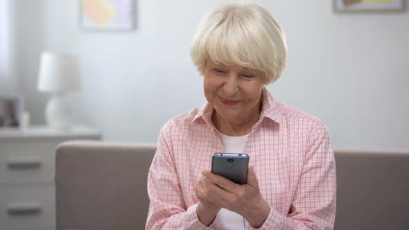 Extremely Glad Senior Woman Scrolling Photos on Smartphone, Social ...