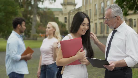 Professor talking with Asian student, discussing science project on ...