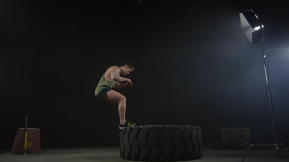 Sportsman Jumping upon Large Tractor Tire, Stock Footage | VideoHive