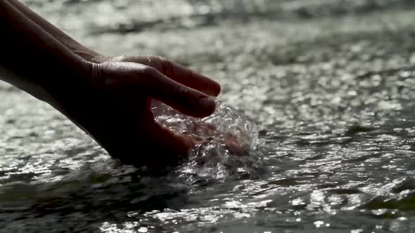 Hands scooping water in current at a waterfall., Stock Footage | VideoHive