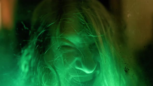 Scary ghost woman screaming through dirty glass on dark background ...