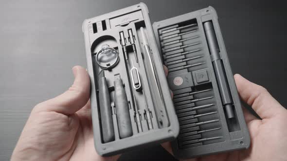 Set of Screwdrivers with Gray Handles in a Box in Male Hands on a Dark ...