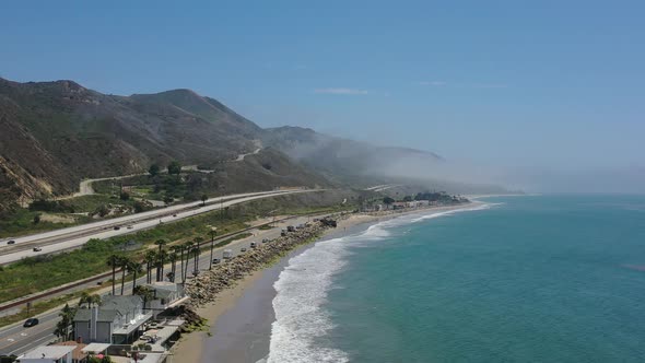 low aerial view of beachfront homes along the ocean next to the famous ...