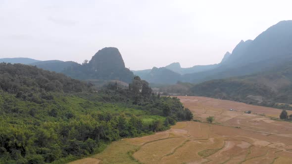 Aerial: flying over rice paddies unique valley scenic cliffs rock ...
