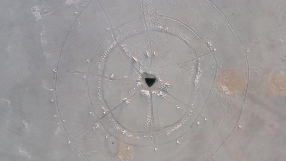 Triangle shaped ice hole on frozen lake. Aerial top-down rising and ...