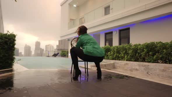 Dancer Rising From Crouch And Turning Against Chair By Poolside, Stock ...