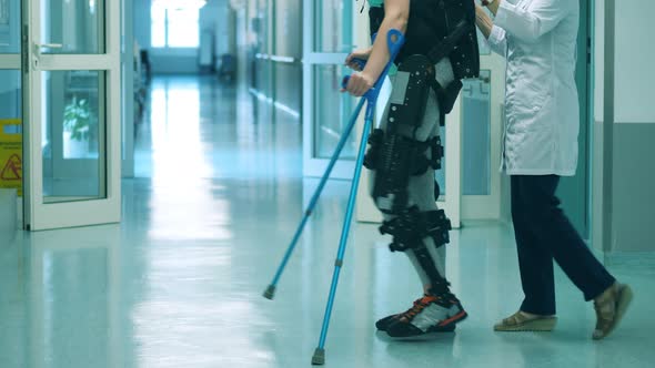 Doctor is Helping a Patient to Walk While Wearing Exosuit, Stock Footage