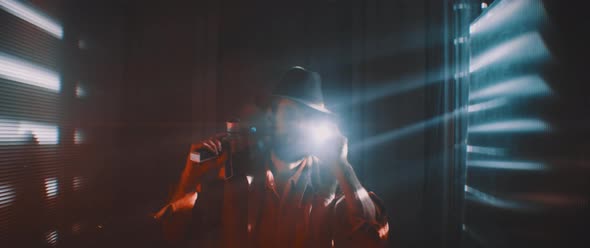Man flashing flashlight towards camera in lights of shutters, Stock Footage