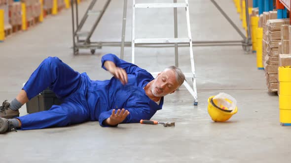 Male warehouse worker falling off ladder while working, Stock Footage