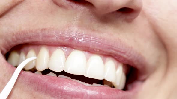 close up woman mouth, clean and floss space between teeth with plastic ...