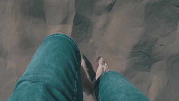 man walking on hot sand. Shot from above capturing feet that sink into ...