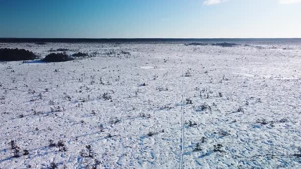 Aerial birdseye view of snowy bog landscape with hiking trail and ...