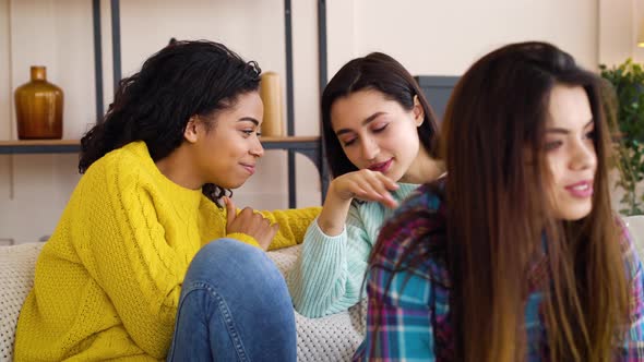Sneaky girls sitting at home and gossiping about their roommate, Stock ...