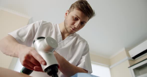 Doctor Treating the Patients Back Muscles with Massaging Percussion ...