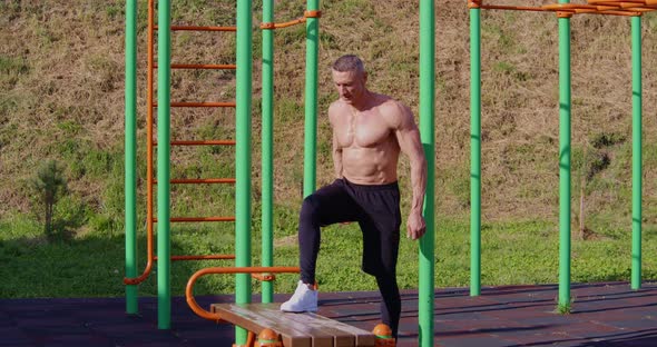 Bodybuilder Doing Step Exercises on Wooden Bench Outdoors, Stock Footage