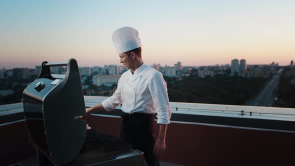 A professional Chef prepares a barbecue on the rooftop of a skyscraper ...