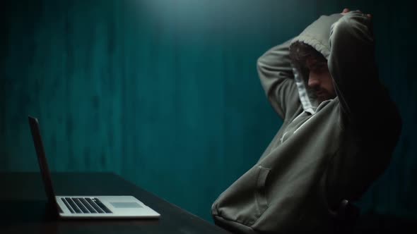 Pensive Hooded Male Hacker Programming on Laptop and Breaking Password ...