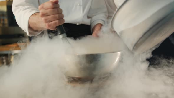 Close-up of a professional kitchen: liquid nitrogen is added during the ...