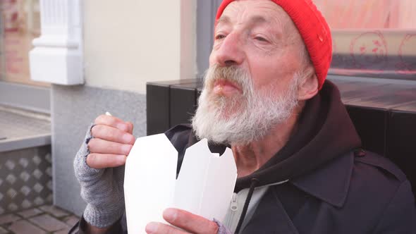 Old-aged Vagabond Sitting on Walking Street and Hungrily Eating, Stock ...