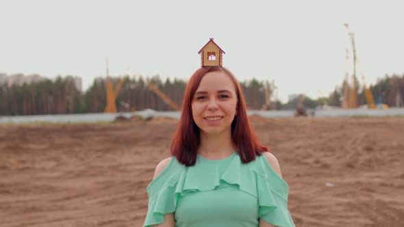 Young Woman with Small Wooden House on Head Stands on Construction Site ...