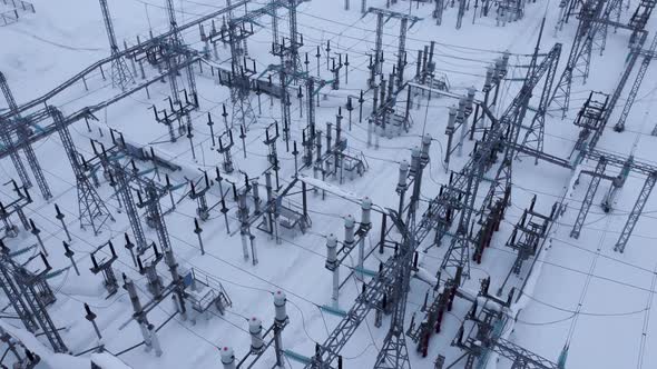 Aerial view of a high voltage electrical substation in cold snowy ...