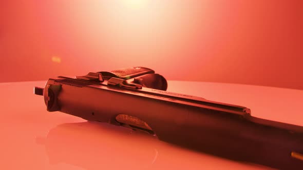 Gun Control. Studio shot of a 9mm gun rotating on a reflective surface ...