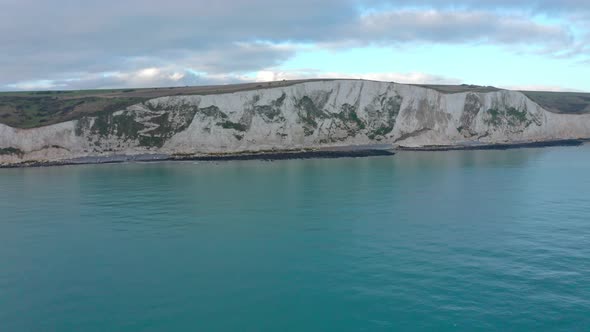 Rising aerial drone shot from the sea towards the white cliffs of dover ...