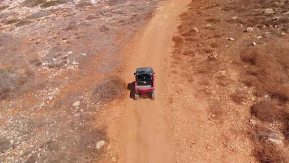 Aerial tracking shot following ATV driving on the Cavo Greko dirt ...