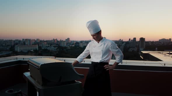 A professional Chef prepares a barbecue on the rooftop of a skyscraper ...