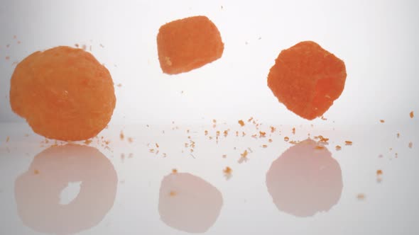 Camera follows cheese puffs falling on surface. Slow Motion., Stock Footage