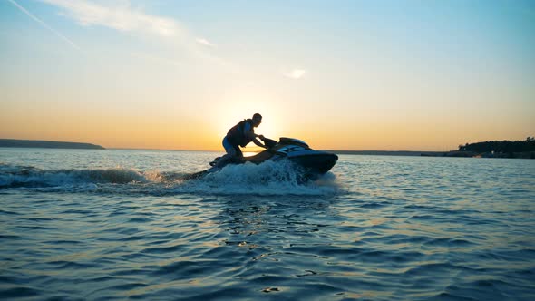Young Person Riding a Waverunner on a Sunset Background, Side View ...