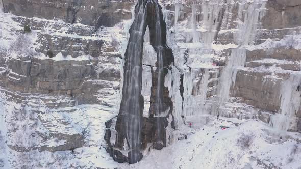 Ice climbers climb a frozen waterfall in extreme conditions - zooming ...