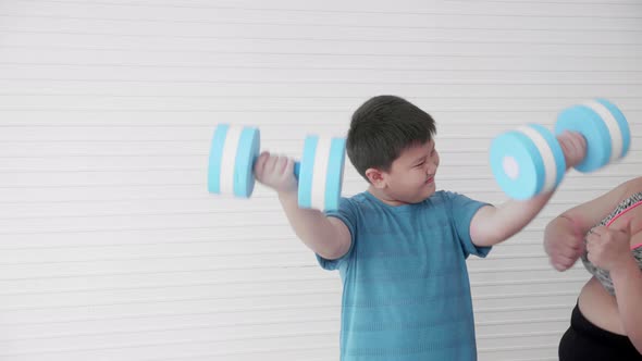 Asian family son fat exercise with dumbbell and mother cheer at home ...