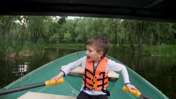 Development Child Rowing Oars on a Boat a Lake Park City, Stock Footage