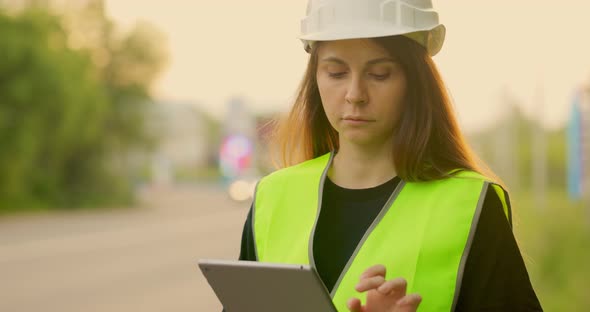 Female Inspector Wearing Helmet and Light Green Vest with Tablet in Her ...