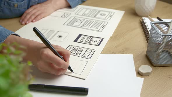 UI designer sketches the user interface of a web application for a ...