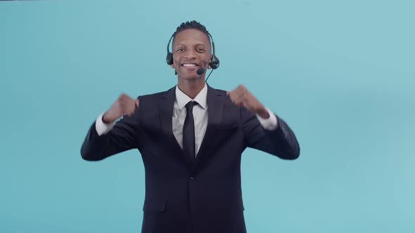 Black Male Cameraman in Headset and in a Strict Suit Smiling Shows the ...