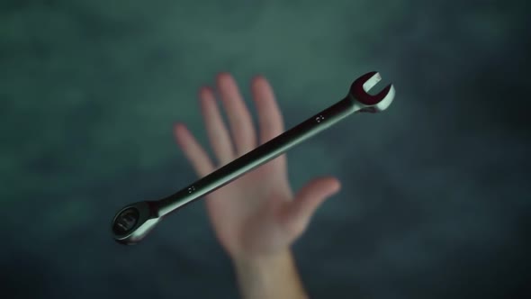 Hand Throwing Up and Catching Metal Wrench Over Table, Stock Footage